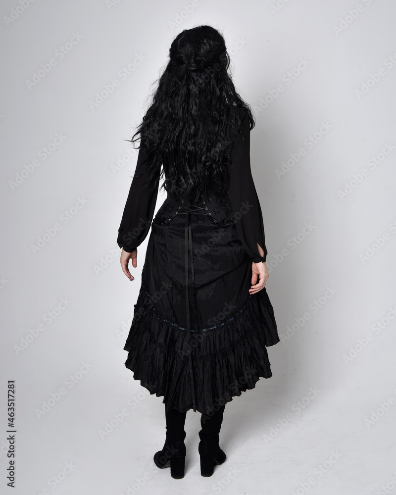 Full length portrait of dark haired woman wearing black victorian witch ...
