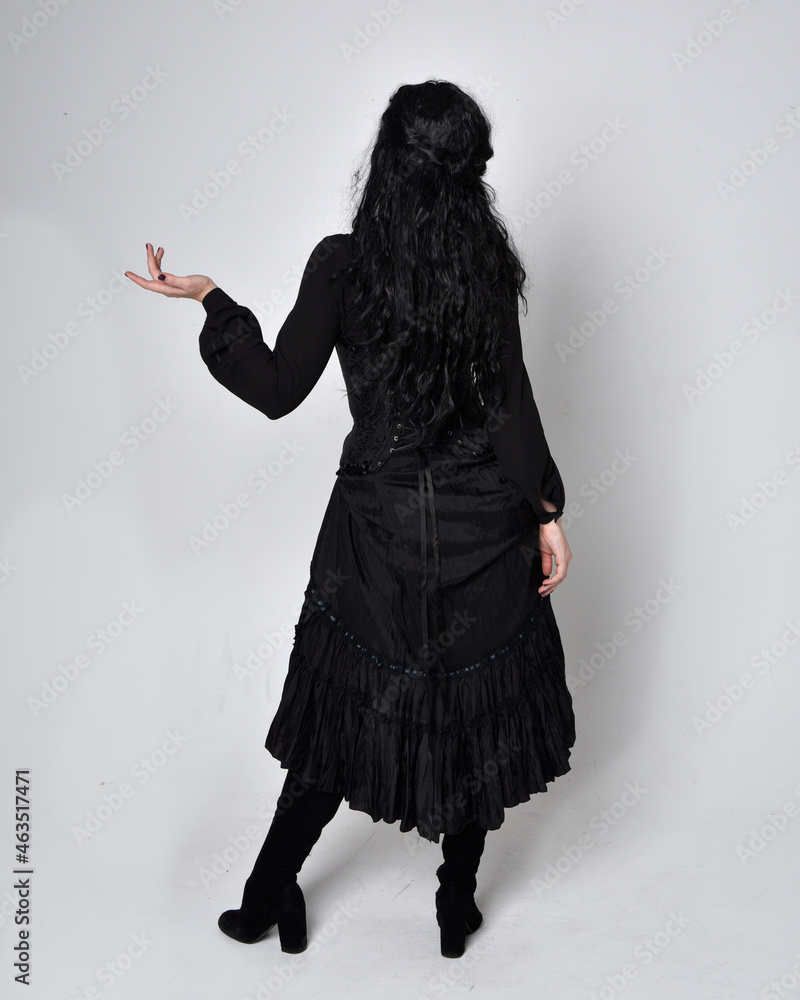 Full length portrait of dark haired woman wearing black victorian witch ...