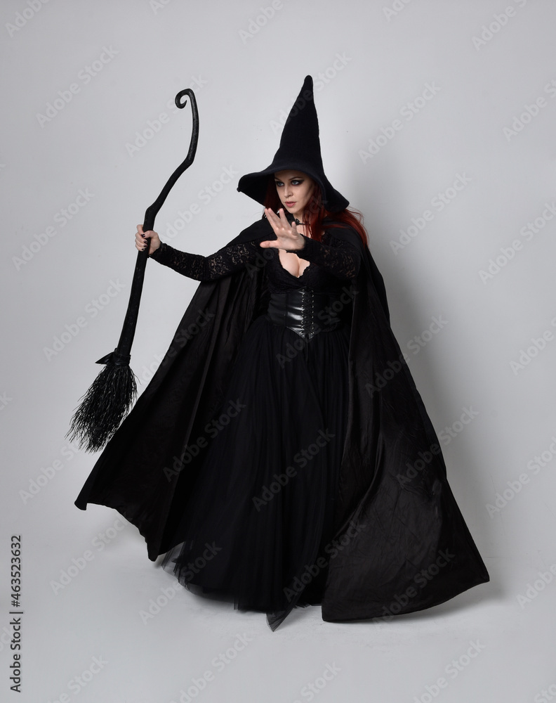 Full length portrait of dark haired woman wearing black victorian witch ...