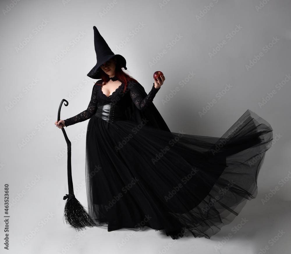 Full length portrait of dark haired woman wearing black victorian witch ...