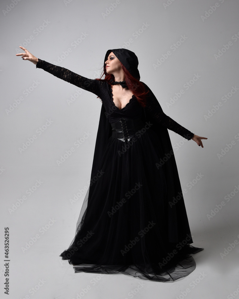 Full length portrait of dark haired woman wearing black victorian witch ...