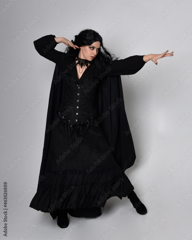 Full length portrait of dark haired woman wearing black victorian witch ...