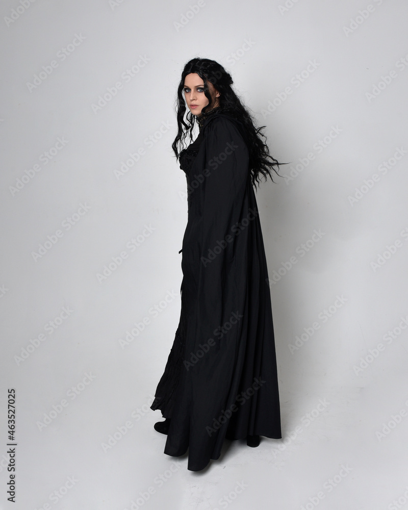 Full length portrait of dark haired woman wearing black victorian witch ...