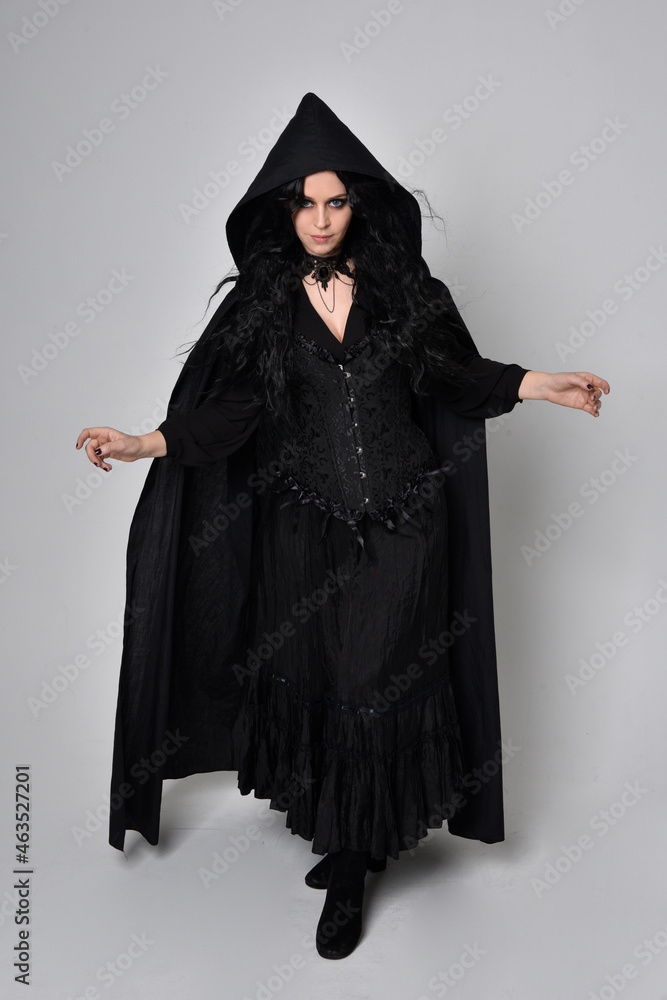 Full length portrait of dark haired woman wearing black victorian witch ...