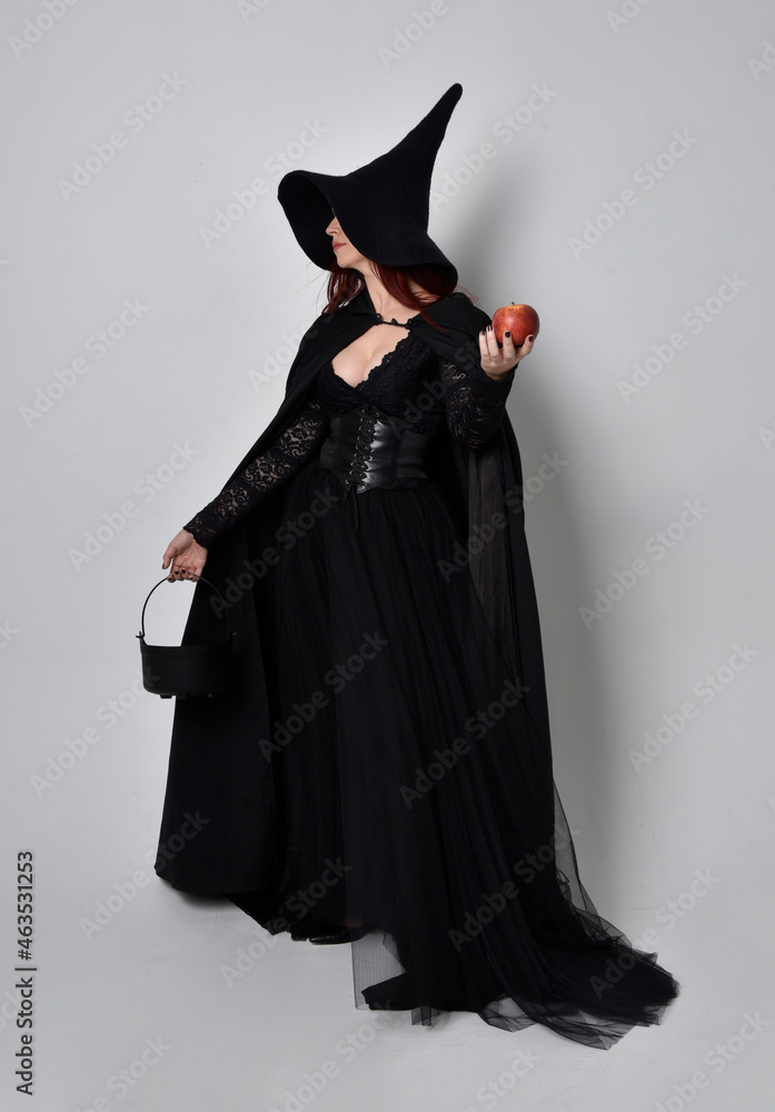 Full length portrait of dark haired woman wearing black victorian witch ...