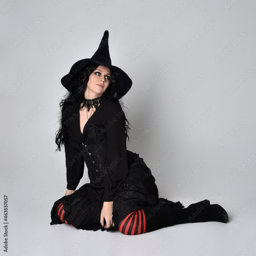 Full length portrait of dark haired woman wearing black victorian witch ...