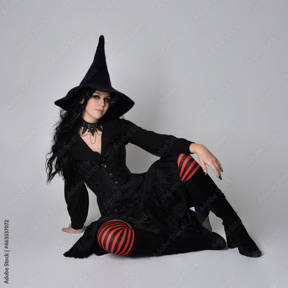 Full length portrait of dark haired woman wearing black victorian witch ...