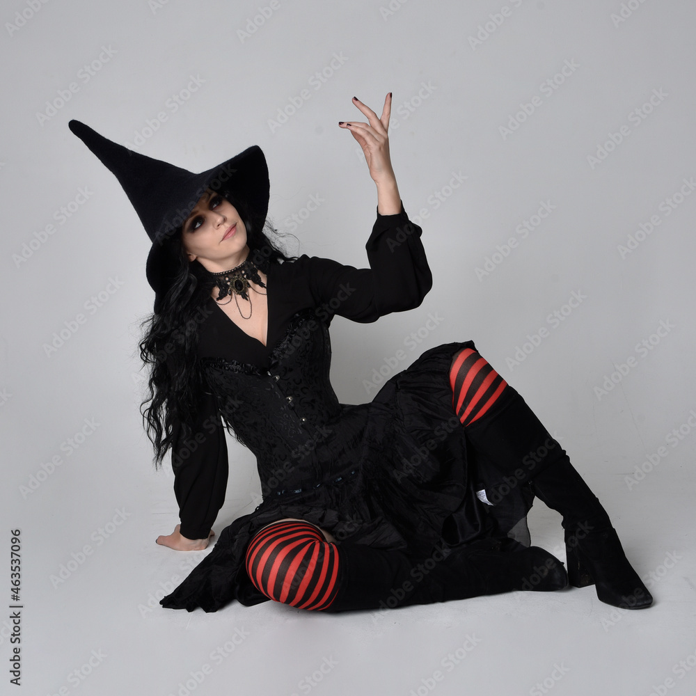 Full length portrait of dark haired woman wearing black victorian witch ...