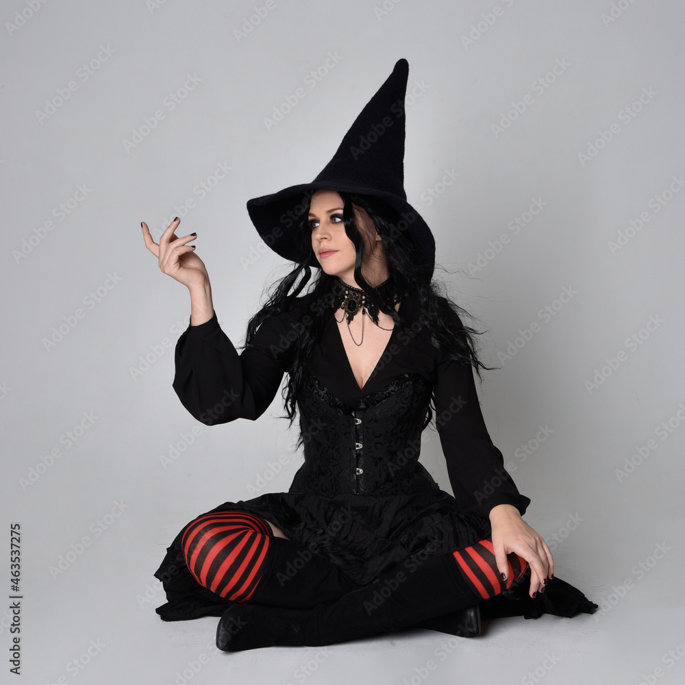 Full length portrait of dark haired woman wearing black victorian witch ...