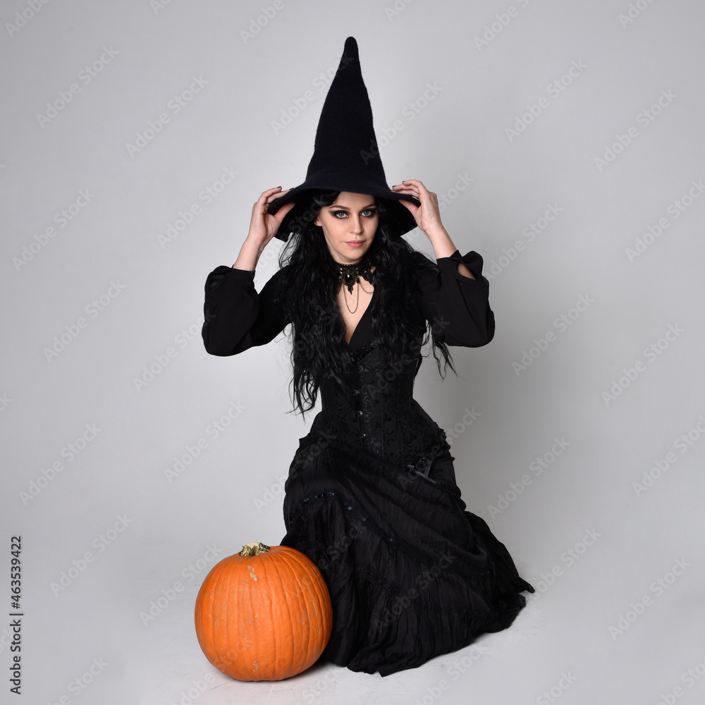 Full length portrait of dark haired woman wearing black victorian witch ...