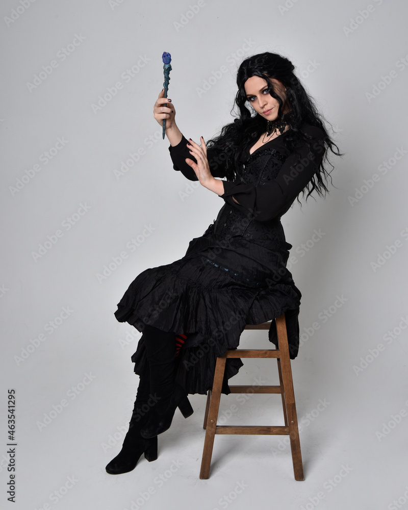 Full length portrait of dark haired woman wearing black victorian witch ...