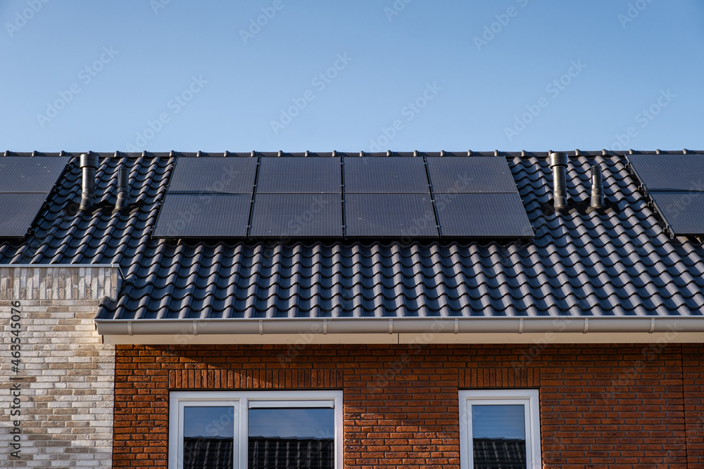 Newly build houses with solar panels attached on the roof against a ...