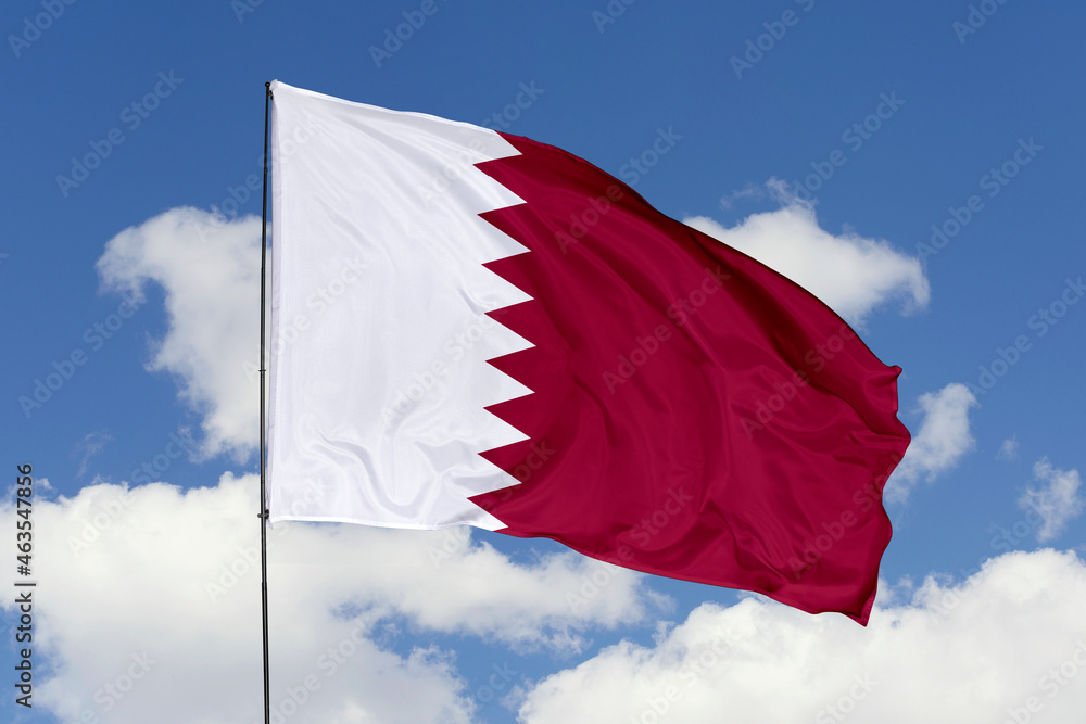 Qatar flag isolated on the blue sky background. close up waving flag of ...