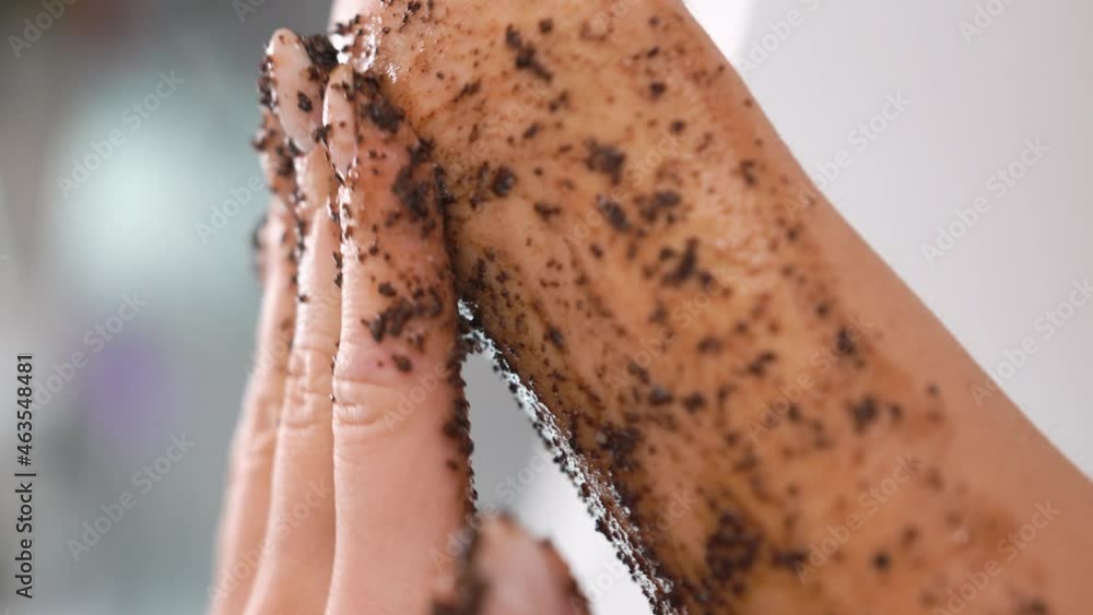 Wideo Stock: close up female smears her body with a coffee scrub, runs ...