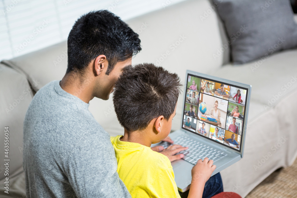 Biracial boy with father using laptop for video call, with elementary ...