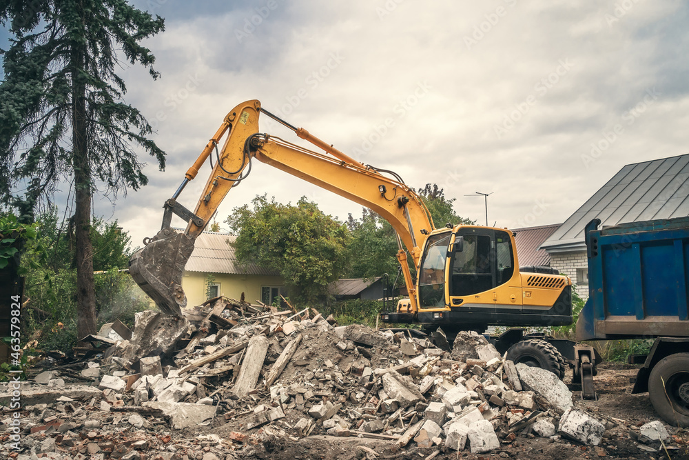 Demolition of building by industrial excavator. Demolished broken walls ...