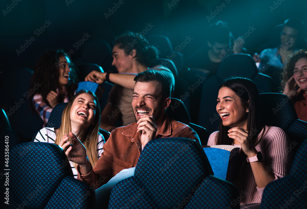 Group of cheerful people laughing while watching movie in cinema. Stock ...