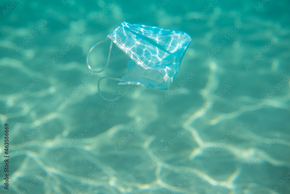 Ocean pollution. Personal protective mask floats underwater ...