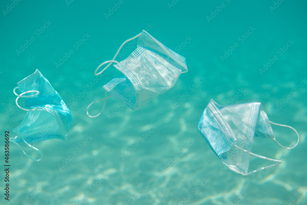 Ocean pollution. Personal protective mask floats underwater ...
