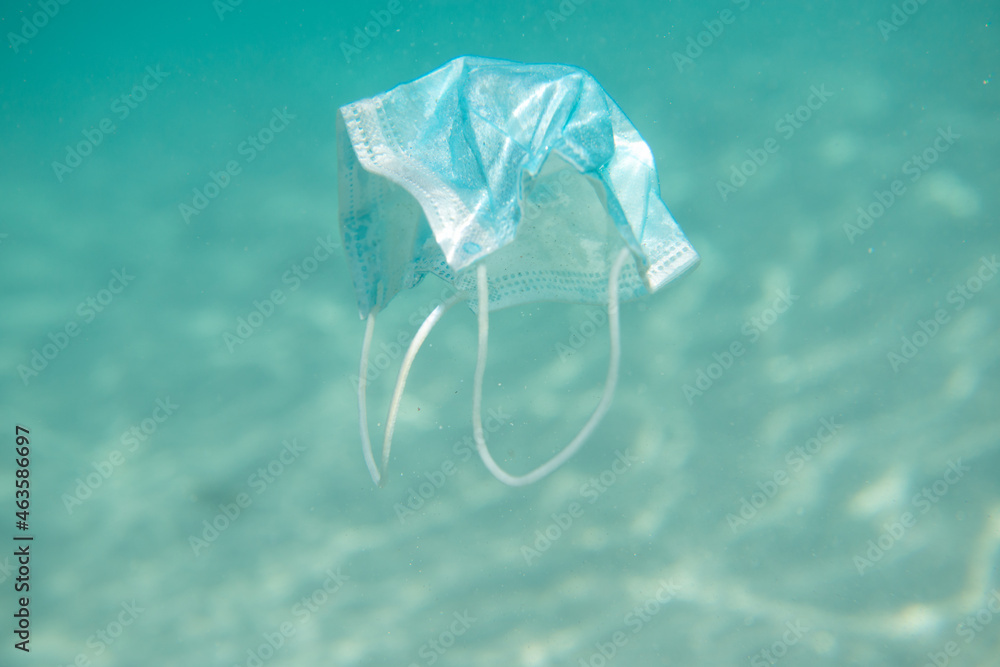 Ocean pollution. Personal protective mask floats underwater ...