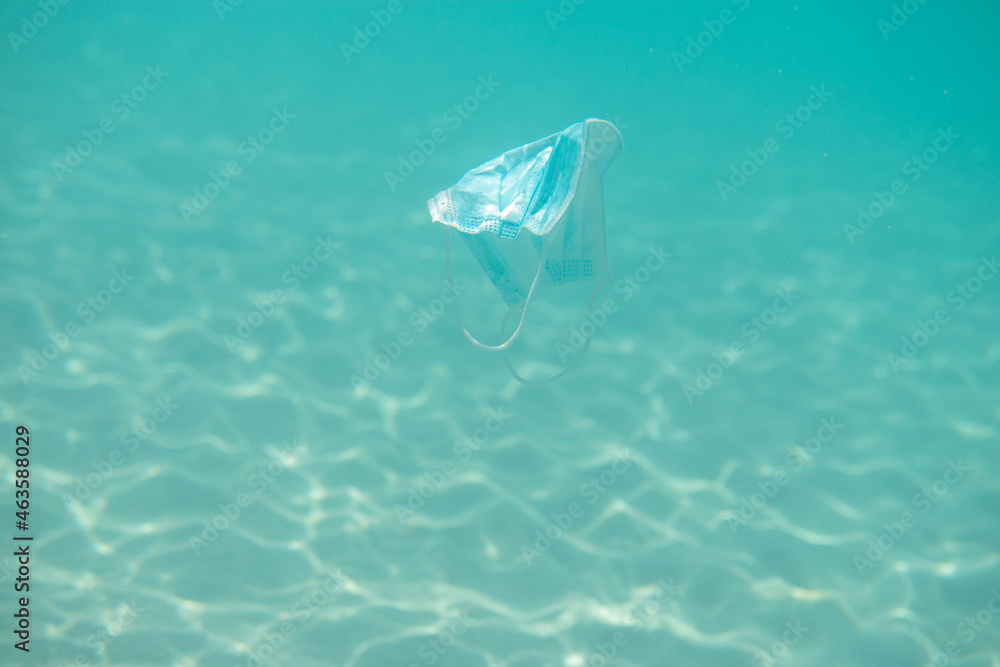 Ocean pollution. Personal protective mask floats underwater ...