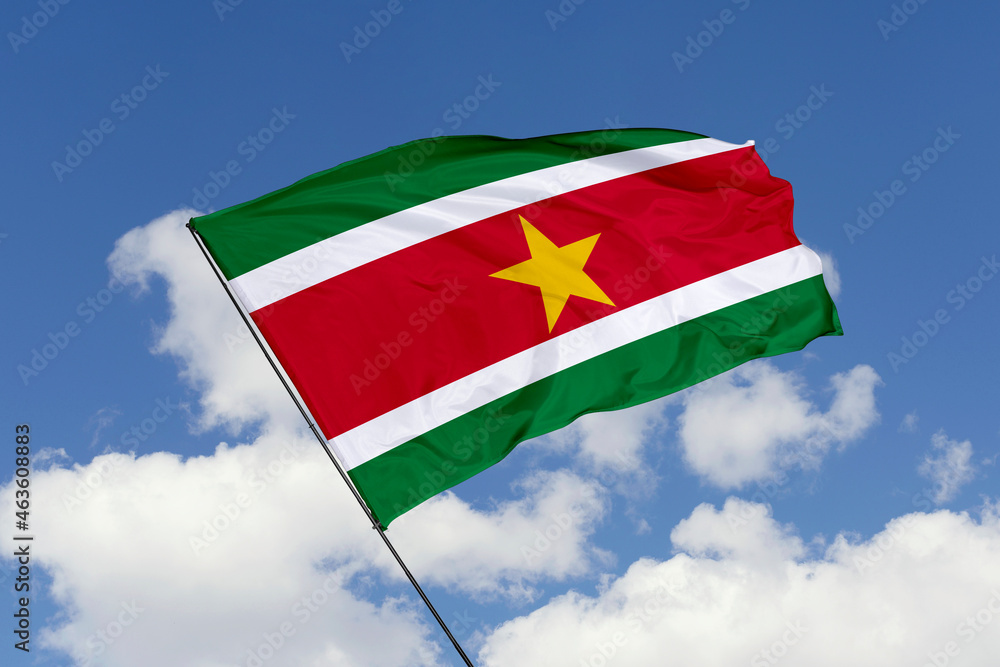 Suriname flag isolated on the blue sky background. close up waving flag ...