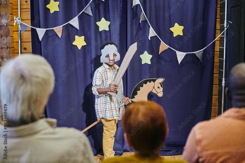 Boy in stage costume acting on the scene, he showing the performance to ...