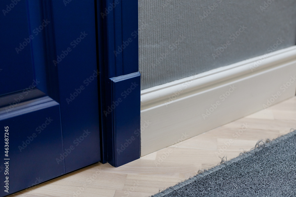 Blue wooden door and adjoining high classic floor plinth. Interior ...