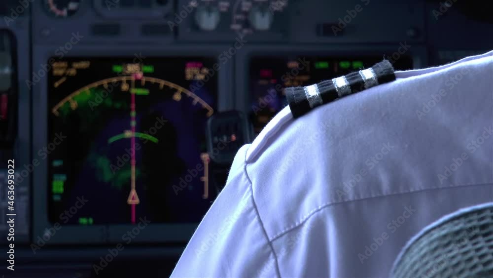 A pilot monitors the flight instruments in the flight deck of a modern ...