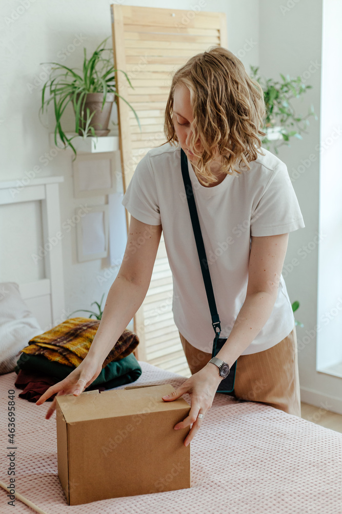 Woman packing wear in box Stock Photo | Adobe Stock