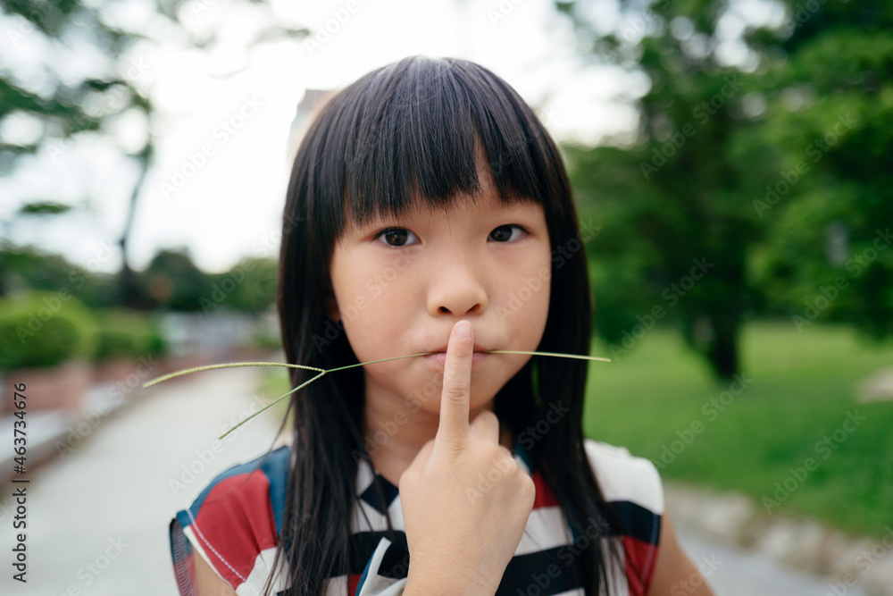 little girl biting a blade of grass Stock Photo | Adobe Stock