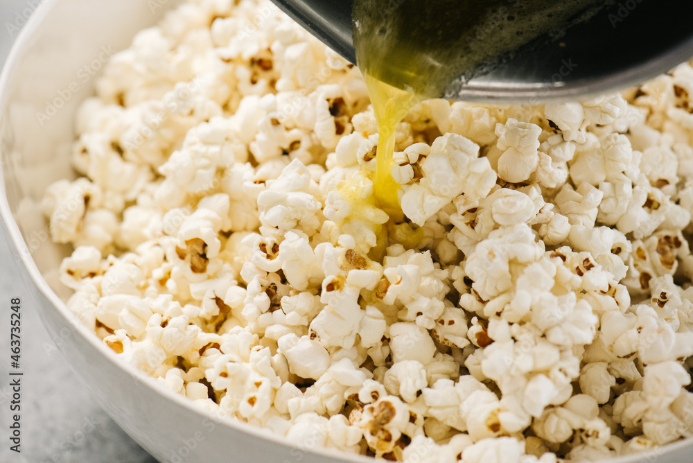Pouring butter onto popcorn Stock Photo | Adobe Stock