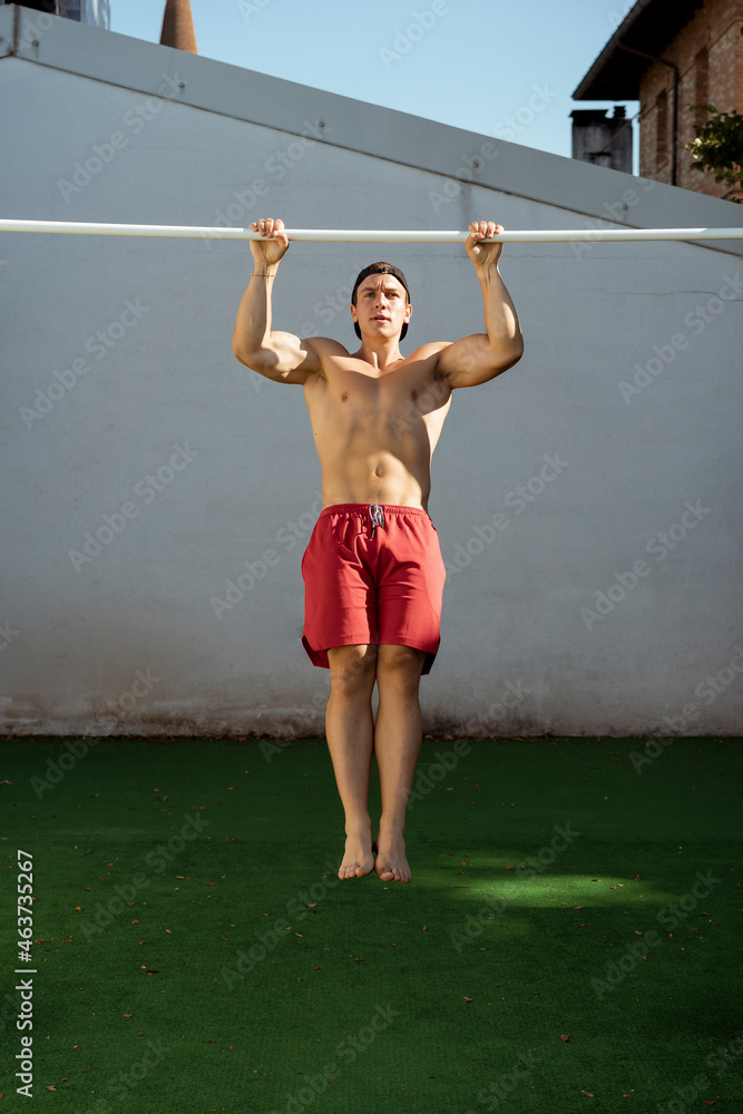 An athlete does pull-ups in an outdoor gym Stock Photo | Adobe Stock