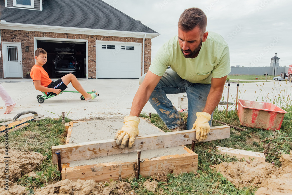 Tradie finising concrete pad. Stock Photo | Adobe Stock