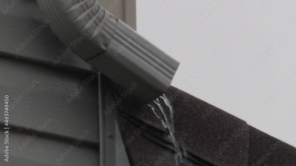 Rain downspout from gutter with water pouring out from second story to ...