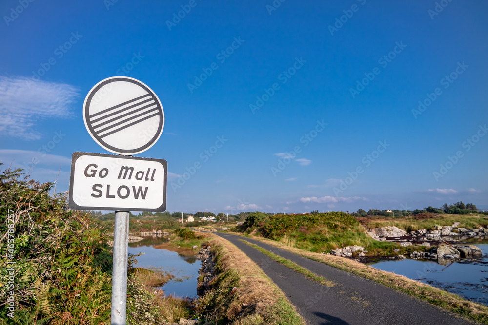Sign asking for driving slow in irish : Go Mall Stock Photo | Adobe Stock