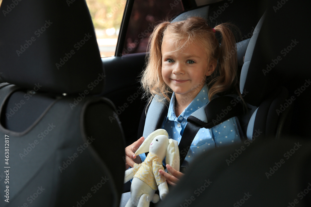 Cute little girl sitting in child safety seat inside car Stock Photo ...