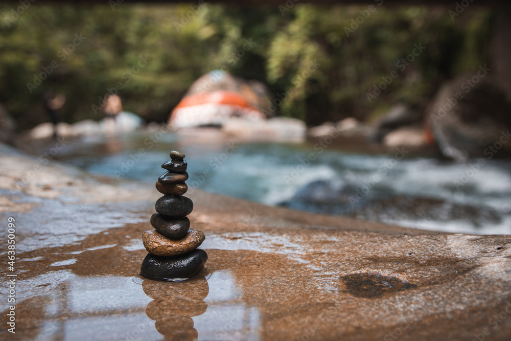 Pila de piedras en equilibrio cerca de un rio en medio de un bosque ...