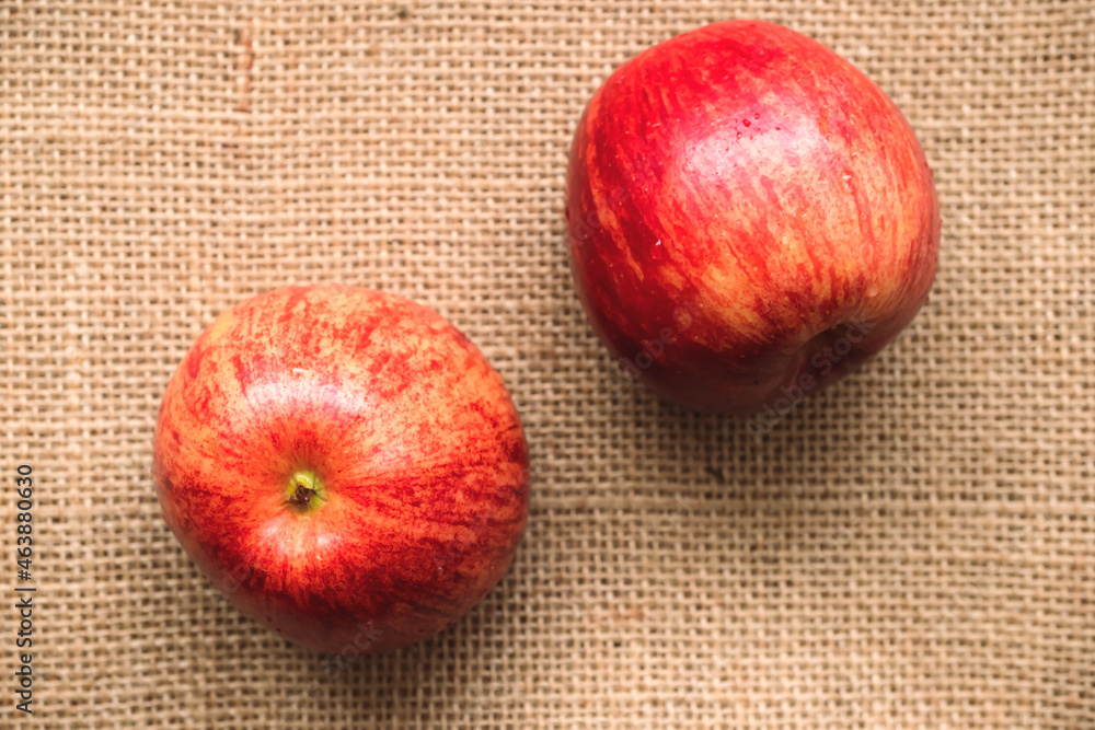 Top view of red apple, 2 sweet red apples placed on a brown sackcloth surface, ready to eat ...
