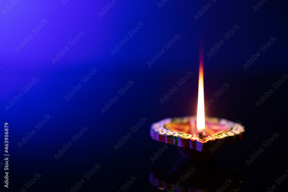 Illuminated Mitti ka Diya With Reflection In Dark Black Background with ...
