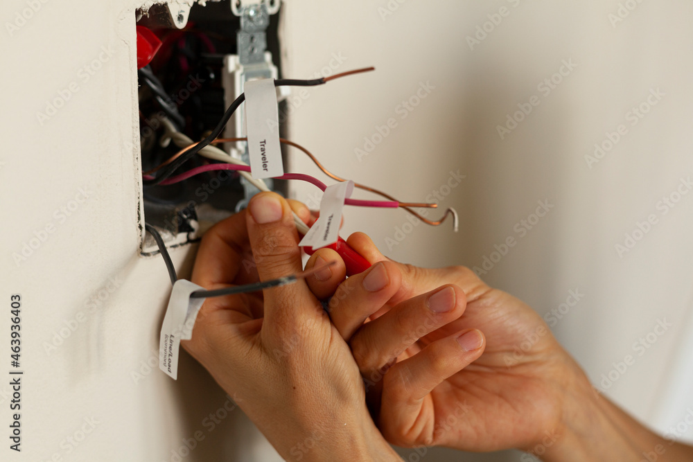 An electrician is replacing a wall switch. A DIY project concept. High ...