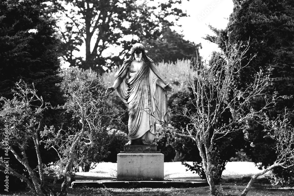 dark spooky cemetery scene with large creepy statue in black and white ...