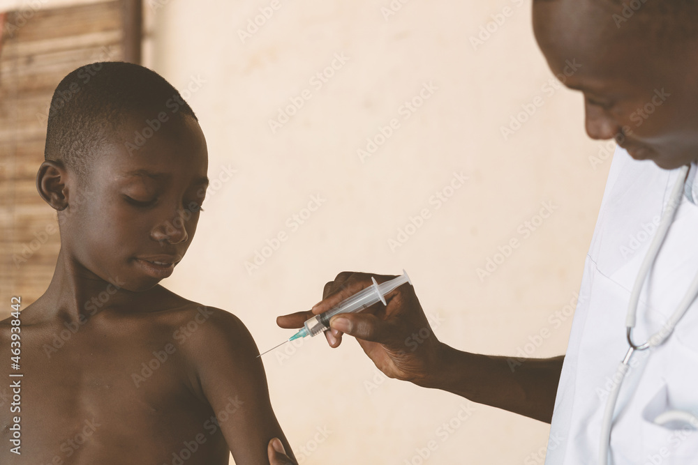 Doctor explains to a small confident looking black boy what happens ...