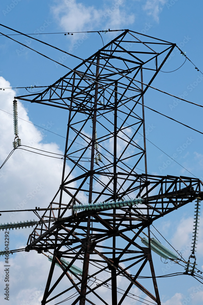 high voltage tower against blue sky bottom view. Power line ...