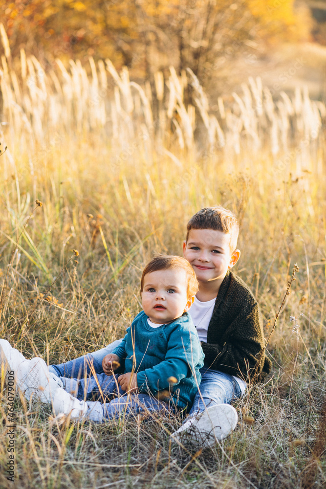 Two little baby brothers sitting together in field Stock Photo | Adobe ...
