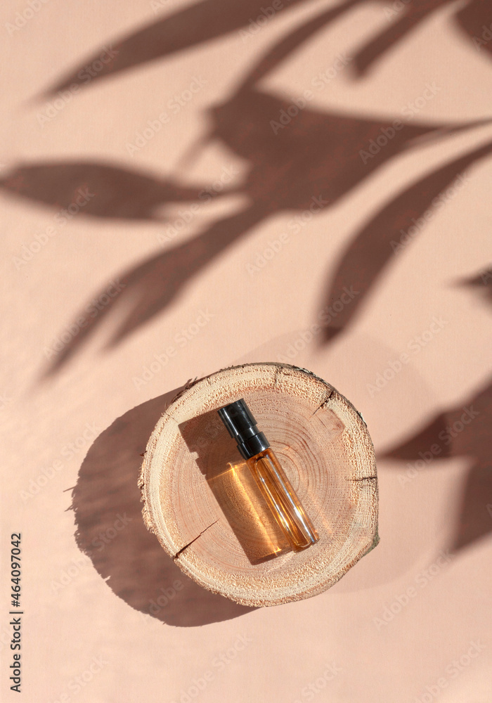 Perfume sample with yellow liquid on wooden tray lying on beige ...