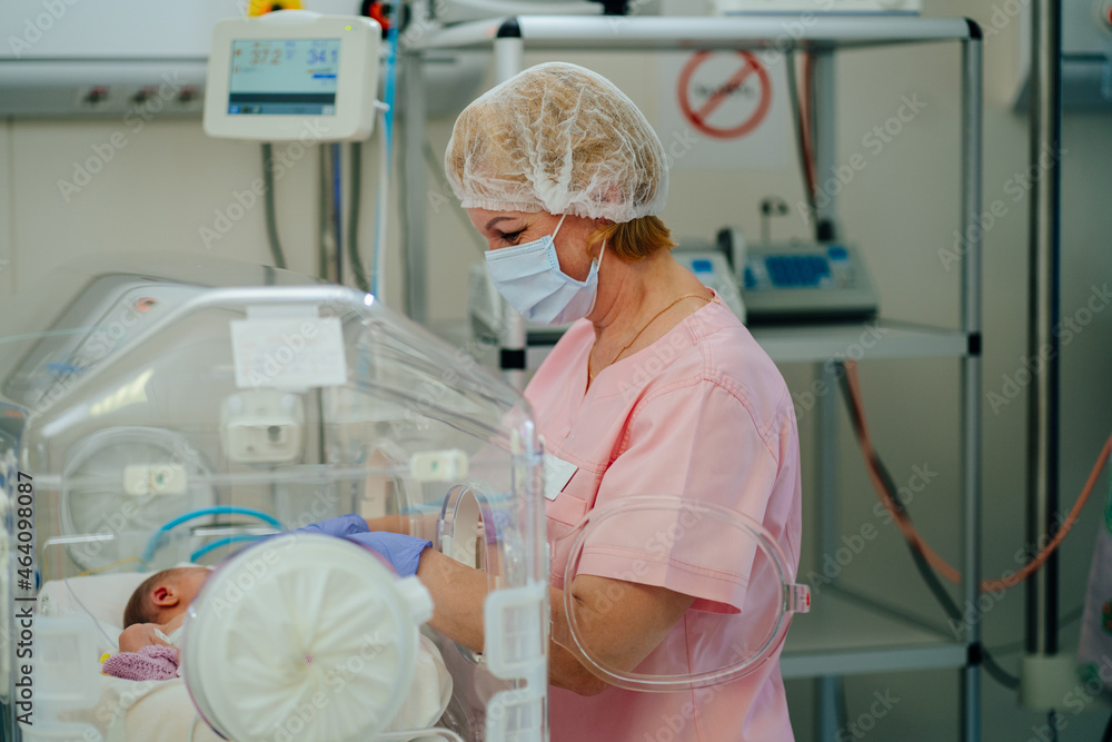 At the intensive care unit. Nurse standing near hospital bed with a ...