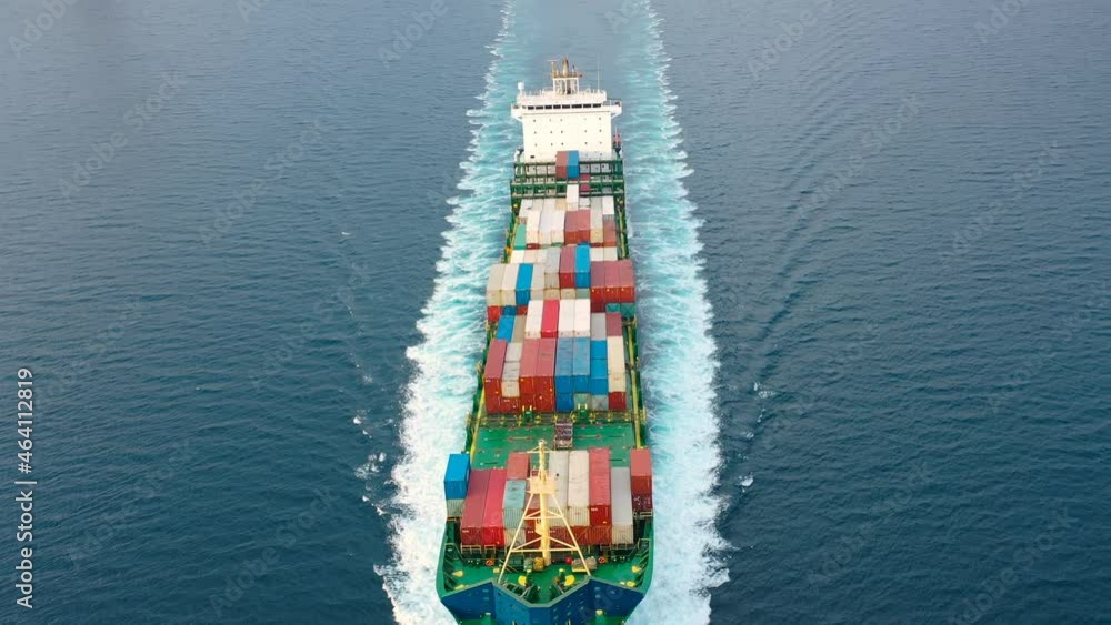Container Ship underway full speed. Turquoise blue and white trails all ...