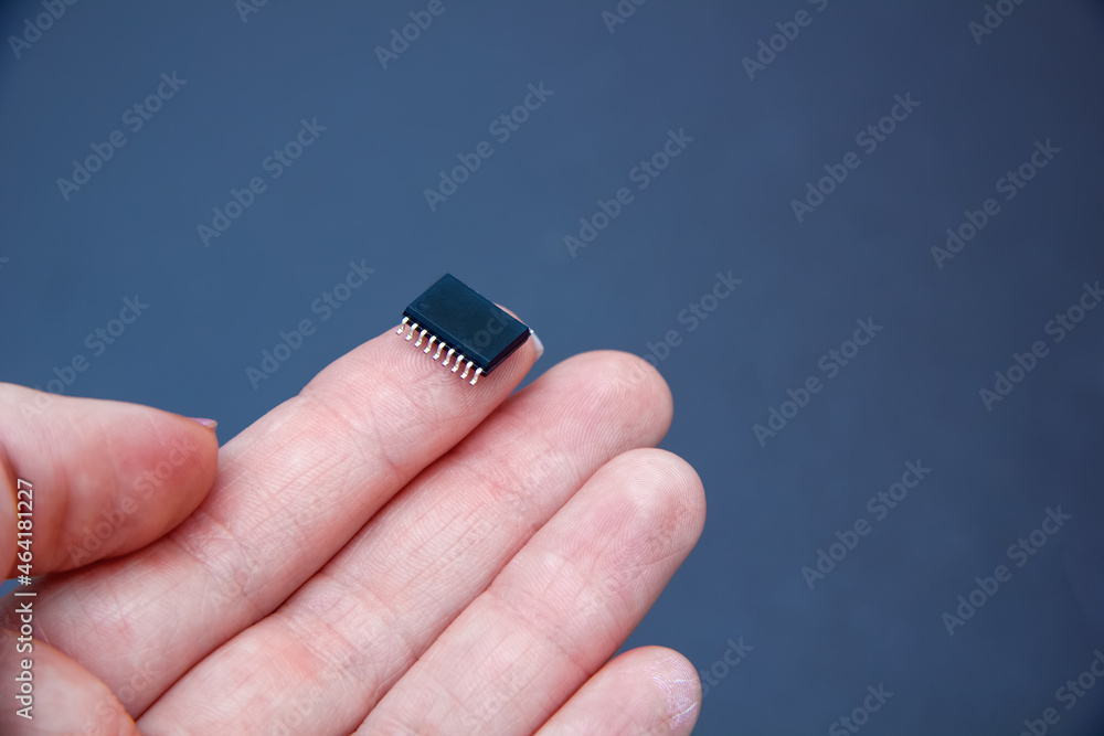 Hand holds chip compenent. Embedding the chip under human skin ...