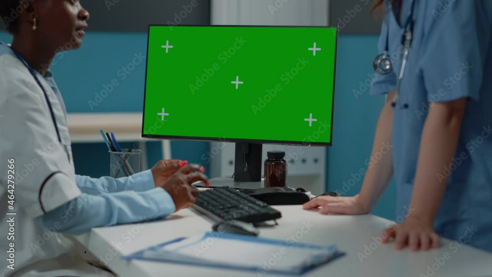 Close up of computer with horizontal green screen on desk while doctor ...